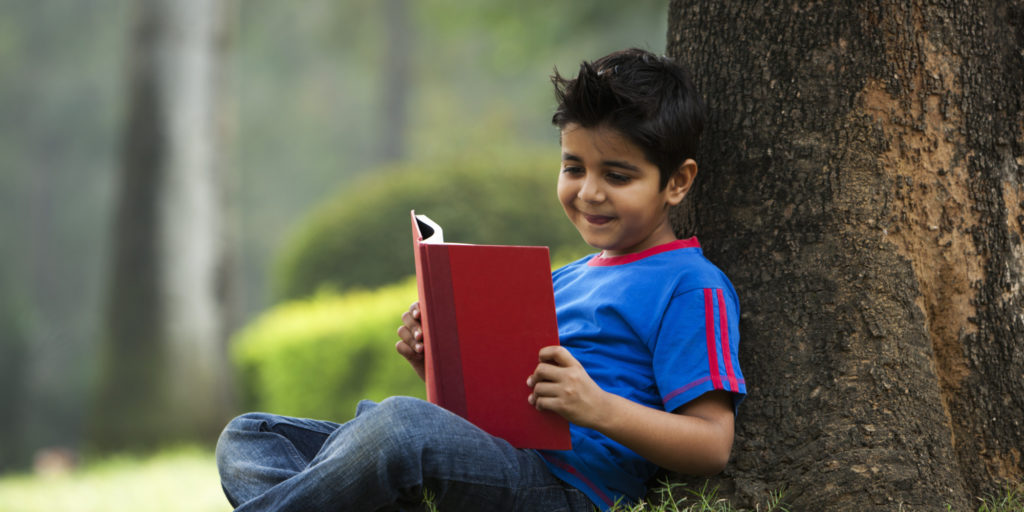 child-reading-under-tree | Ameya World School child-reading-under-tree | Ameya World School